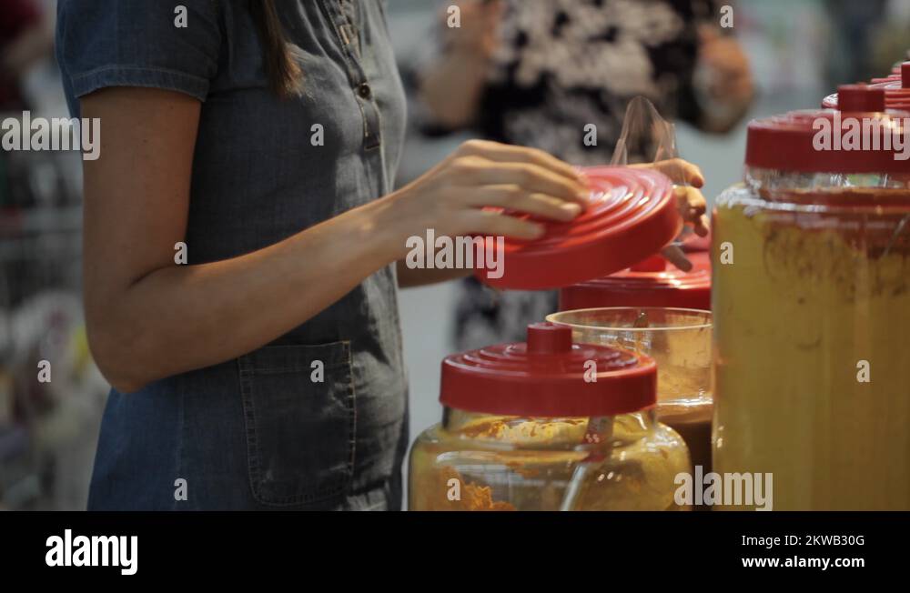Two young womans choosing spices in grocery section at supermarket ...