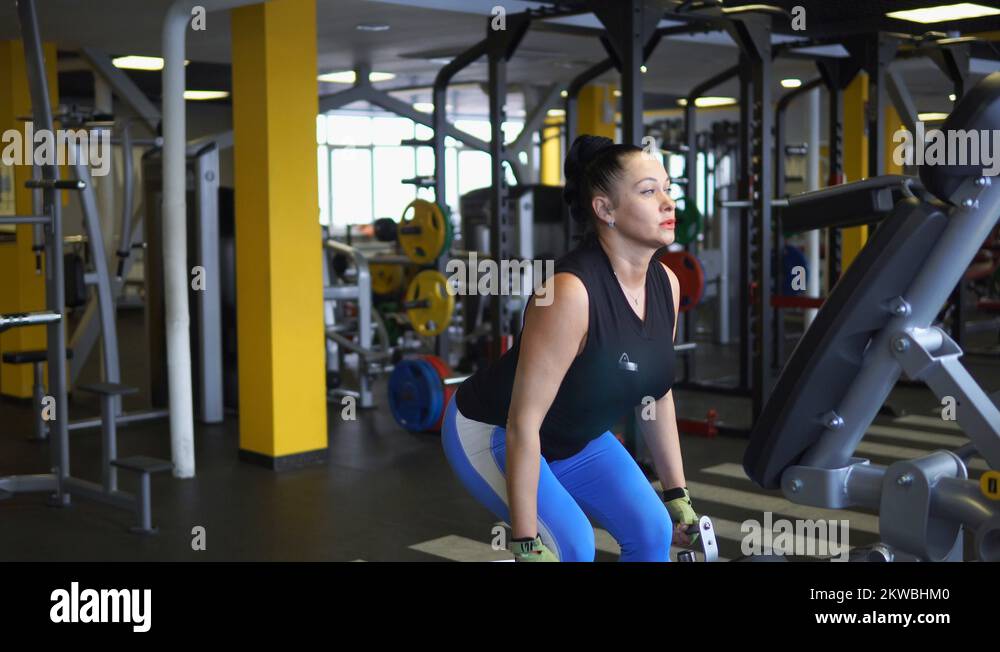 A middle-aged woman doing sit-ups with a simulator in her arms Stock ...