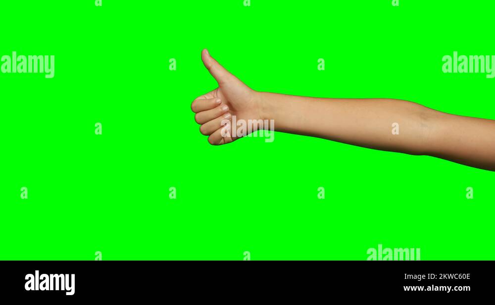 Person making hand gesture of thumbs up against green screen background ...