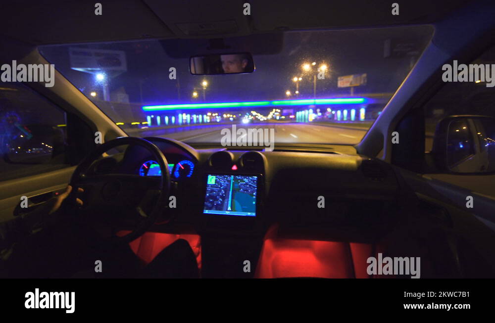 The man drive a car on the city road. inside view. evening night time ...