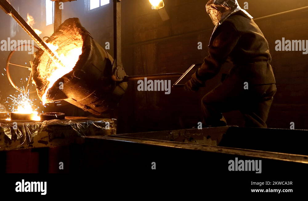 Worker controlling metal melting in furnaces. Workers operates at the ...