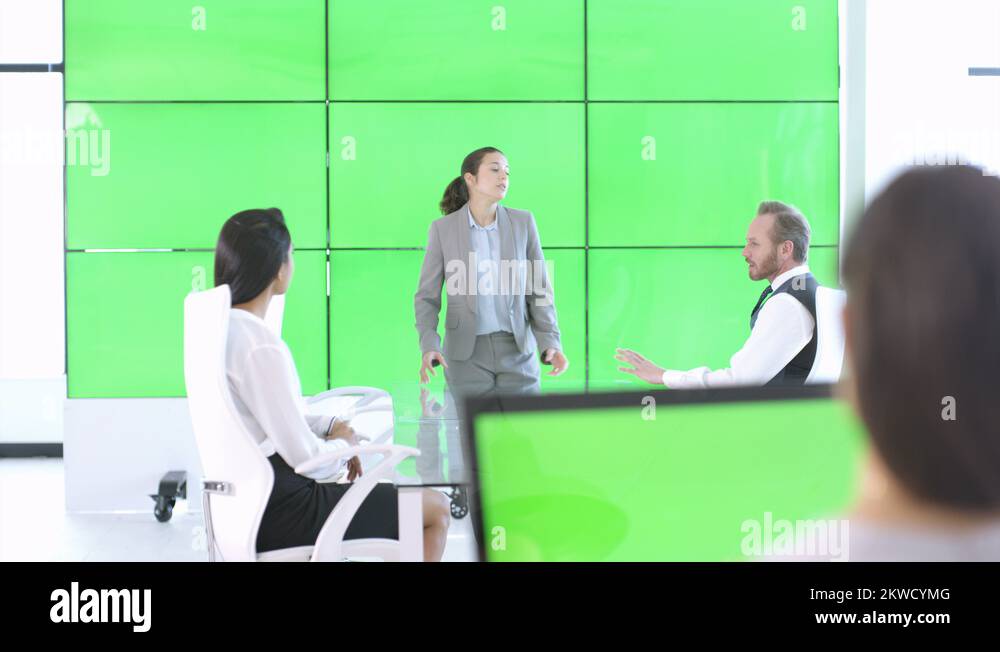 4K Business management team in a meeting with green screen video wall ...