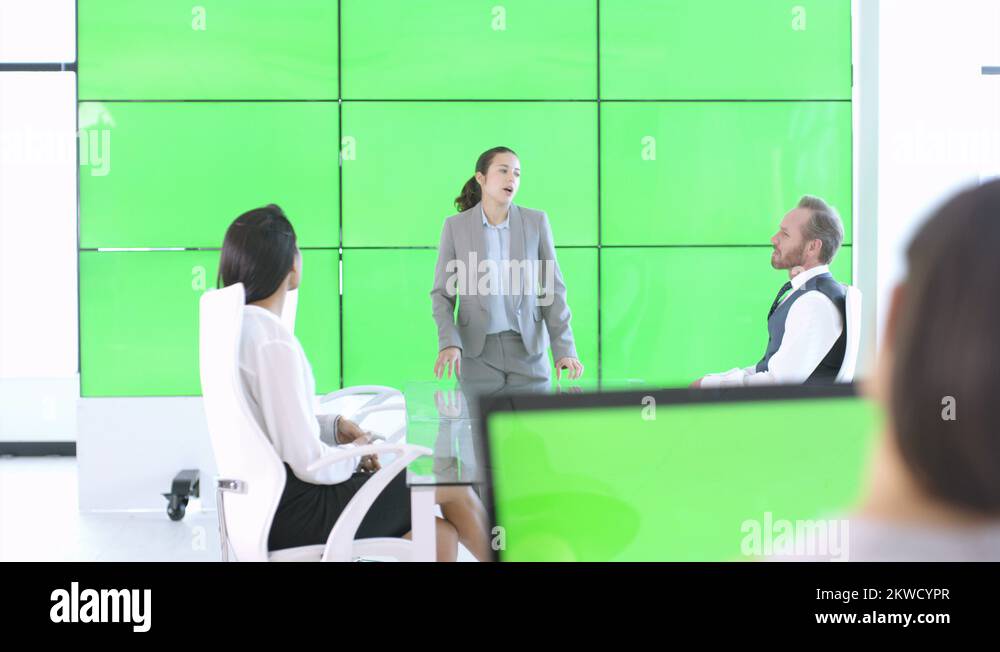 4K Business management team in a meeting with green screen video wall ...