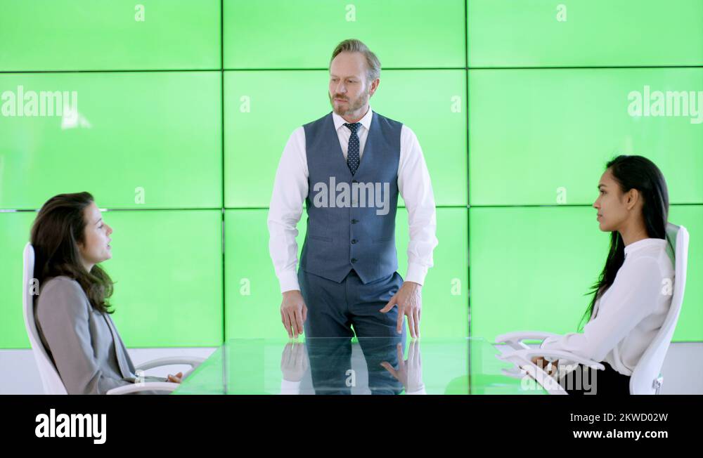 4K Business management team in a meeting with green screen video wall ...