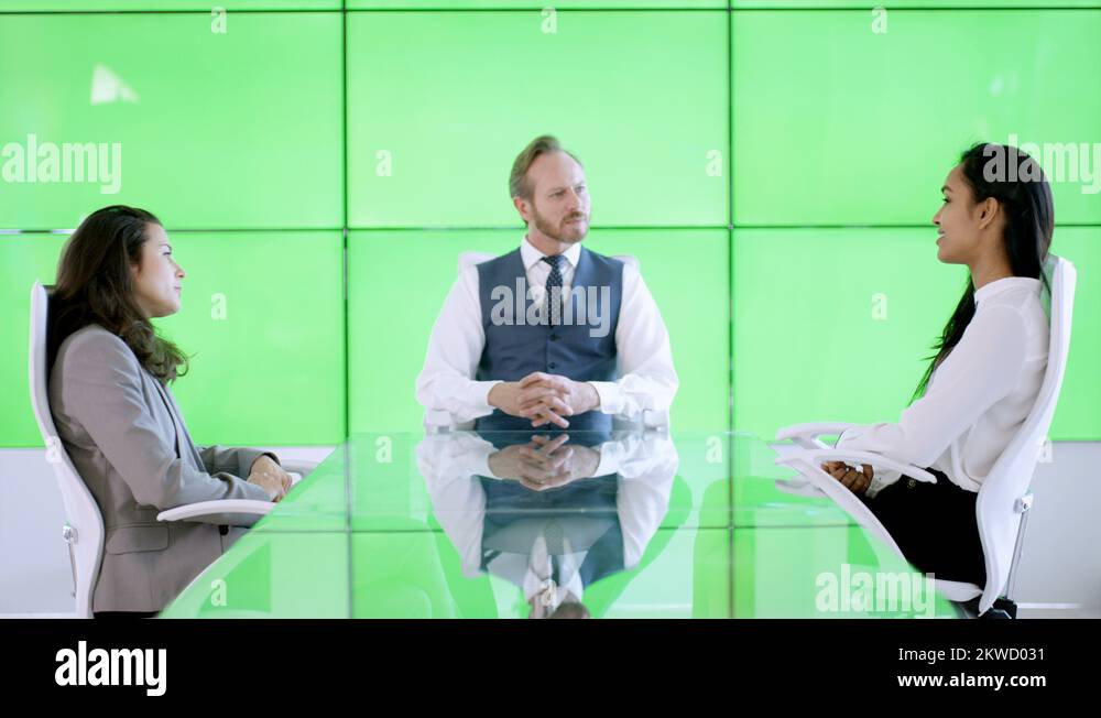 4K Business management team in a meeting with green screen video wall ...