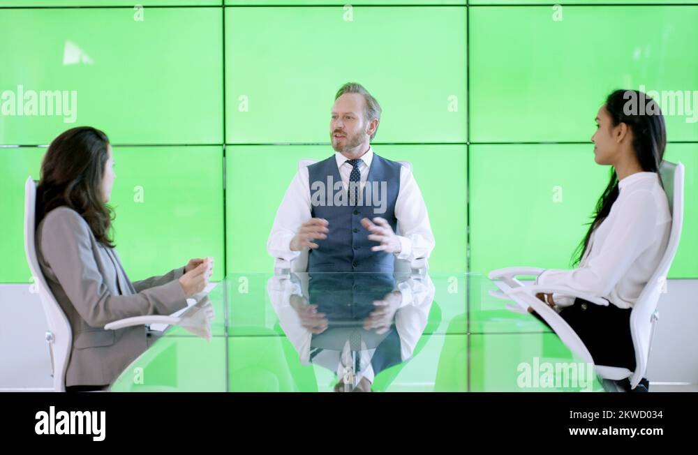 4K Business management team in a meeting with green screen video wall ...