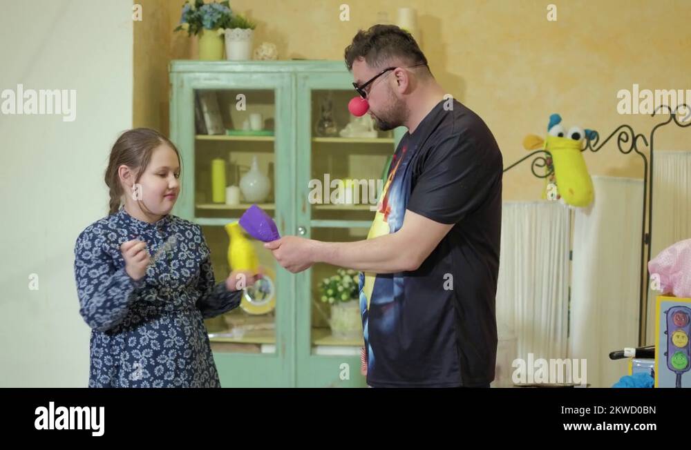 The clown shows the girl a trick with magic bottles and a rope 4k Stock ...