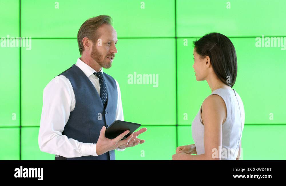 4K Business man & woman looking at tablet with green screen, on green ...