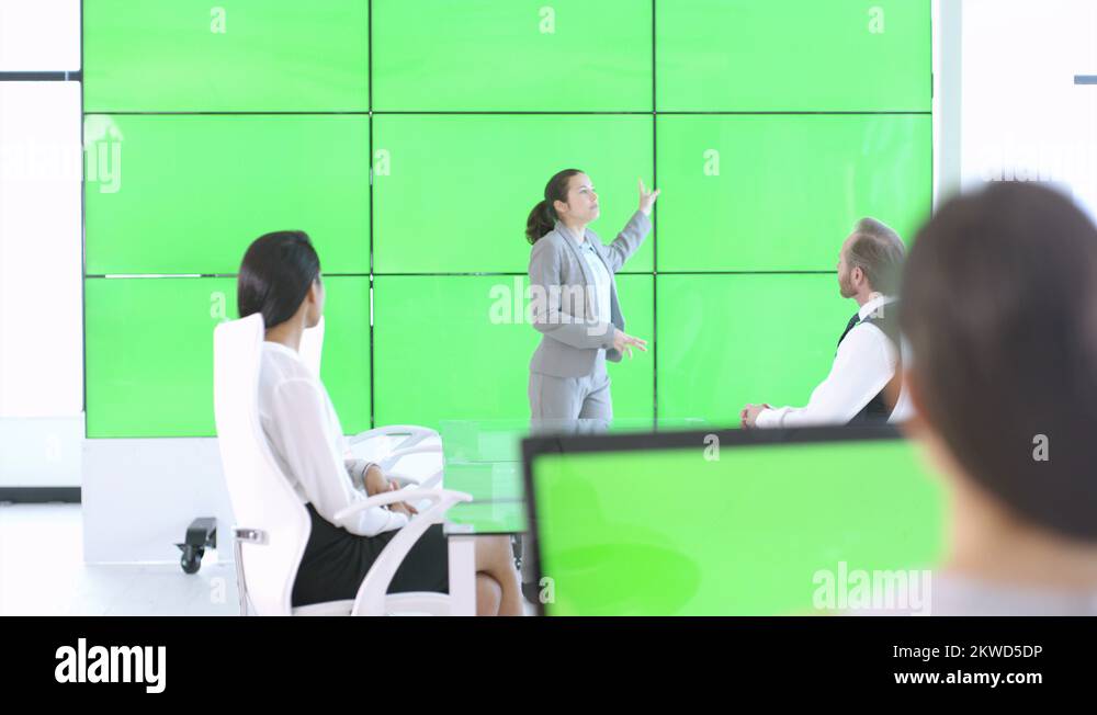 4K Business team in a meeting, interacting with large green screen ...