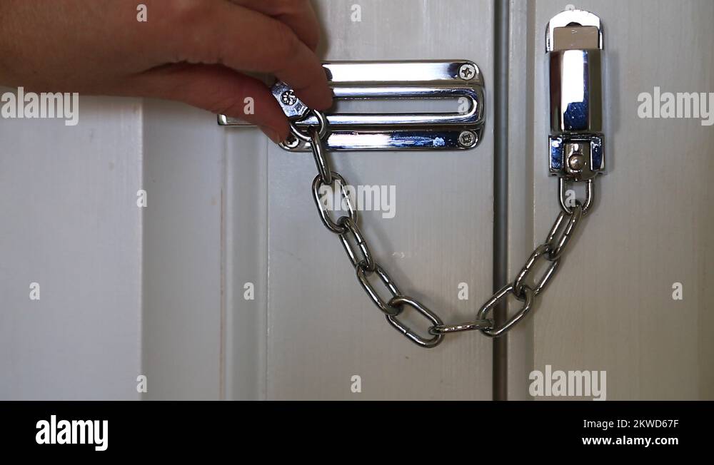 Woman moves safety chain to open the door Stock Video Footage - Alamy