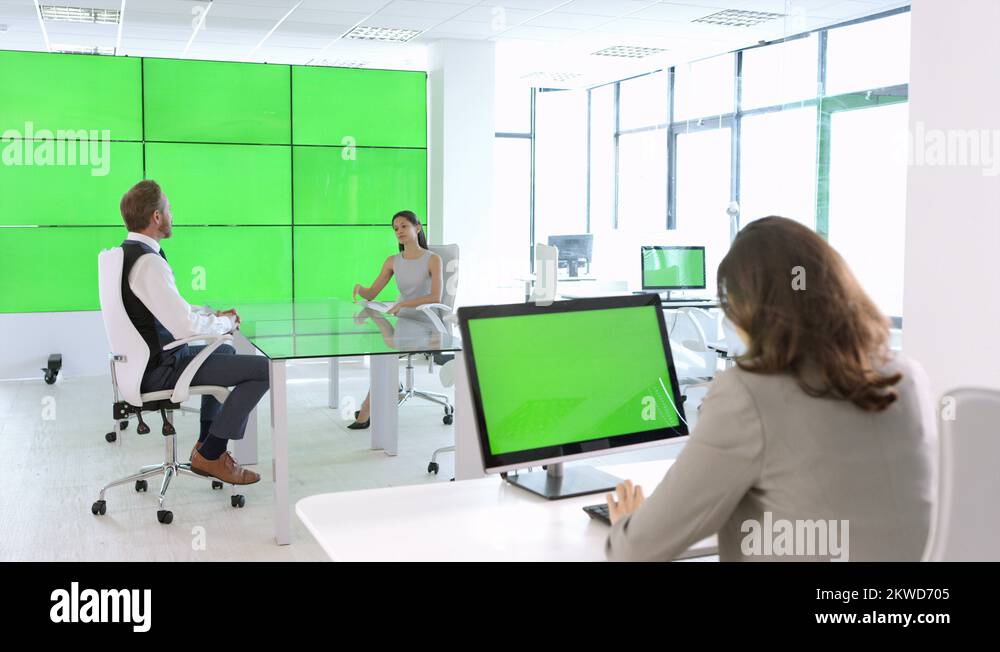 4K Business team in modern office green screen on video wall & computer ...