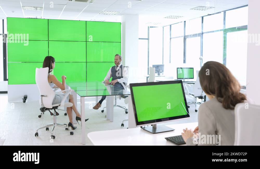 4K Business team in modern office green screen on video wall & computer ...