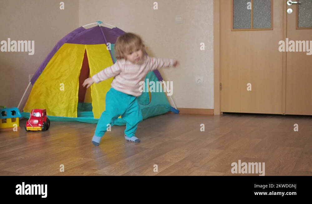Active baby boy dancing at home. Little child frolics, jumps and rolls ...