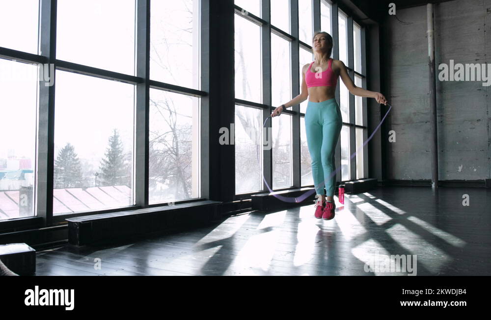 Young pretty athletics girls skipping on drill at gym against barred ...