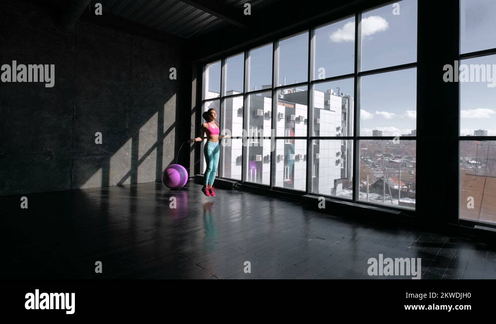 Young pretty athletics girls skipping on drill at gym against barred ...