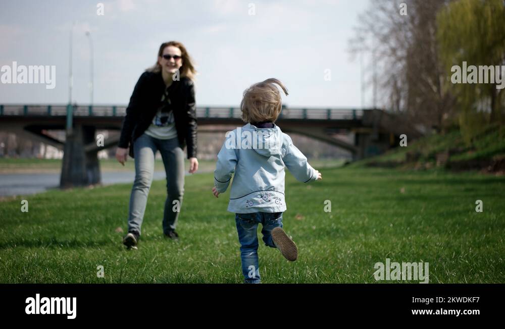 Child Running Into Mother's Hands to Hug Her and Spinning Around ...