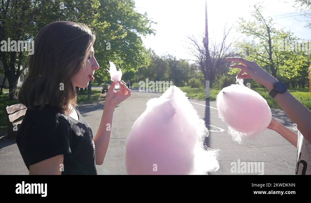 Young girls have fun eating sweet cotton candy riding Segways ...