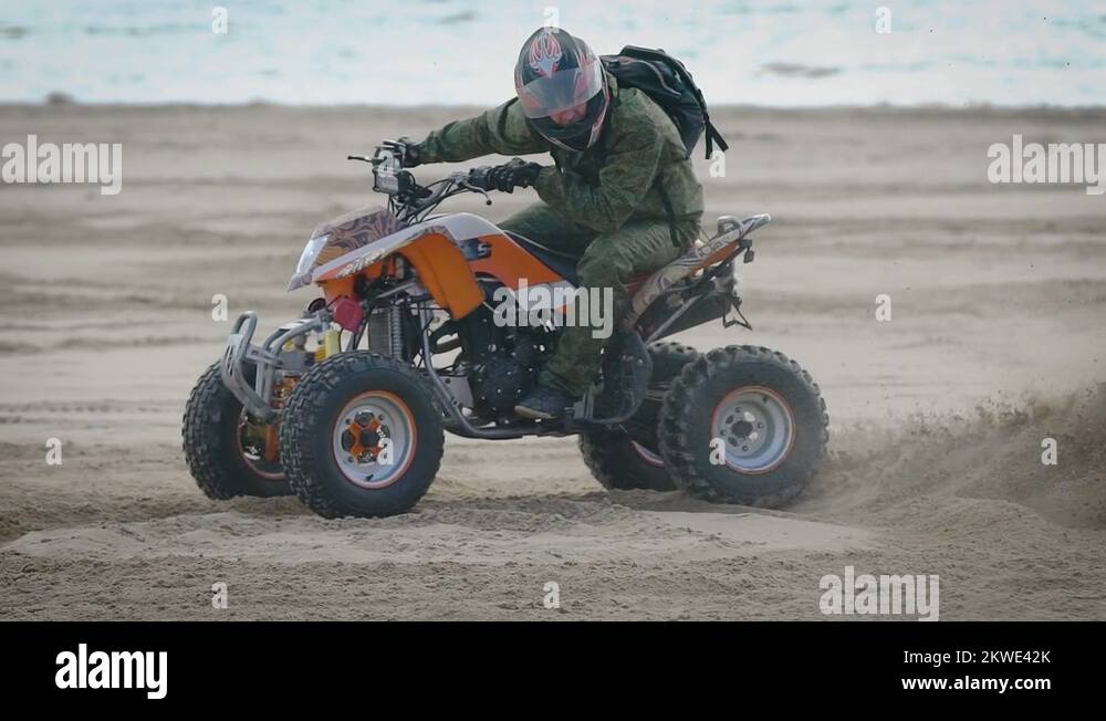 River bank. The racer works the movements on the quad bike. The man on ...