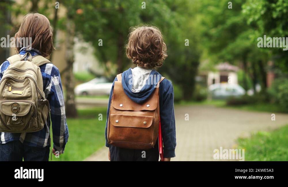 Two boys and girl are returning home after the school. The girl catches ...