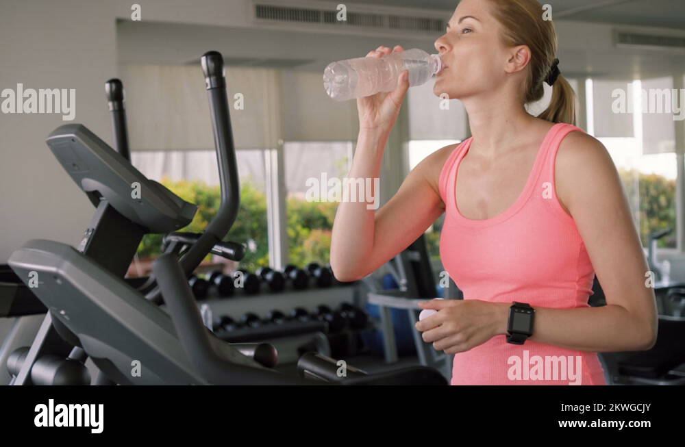 Beautiful fit young woman in a gym doing exercises on a velosimulator ...