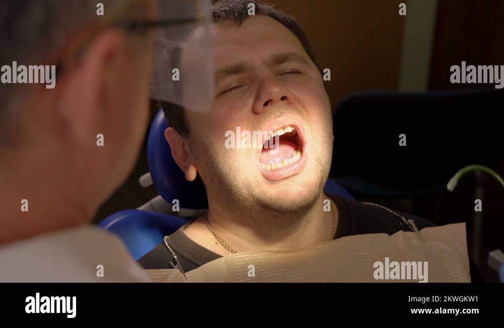 Dentist Medical Gloves Inserts Into The Oral Cavity of the Patient ...
