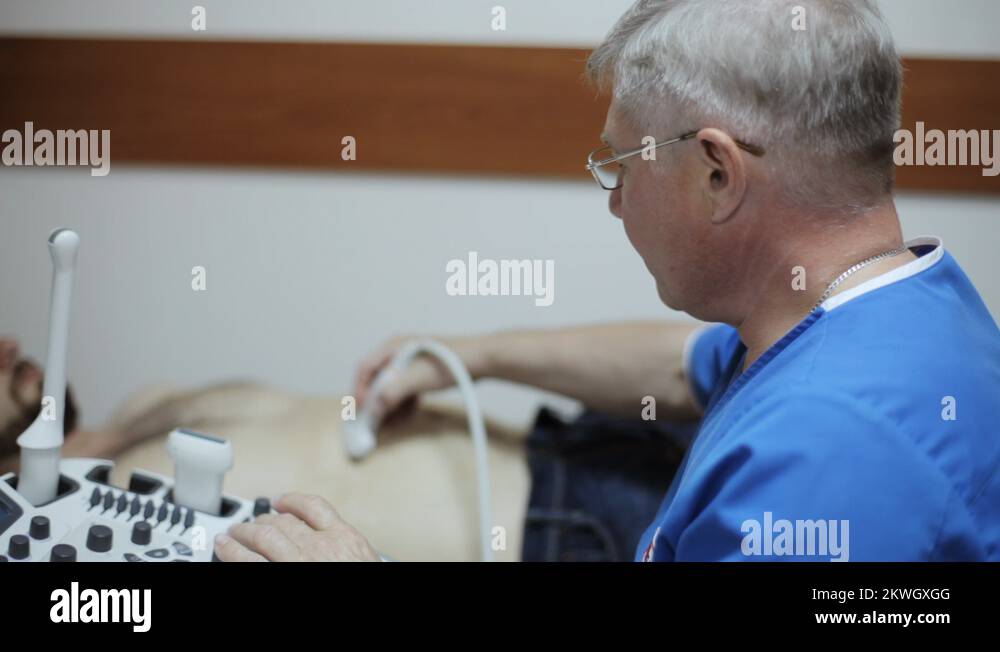 Doctor radiologist examining abdomen of male patient with ultrasound ...