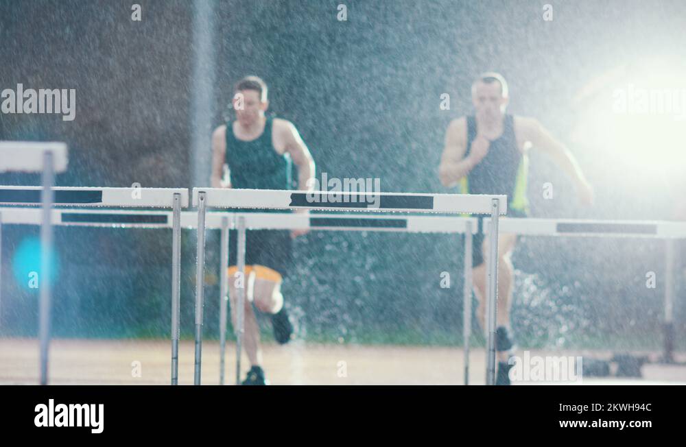 4K Athletes running & jumping over hurdles at athletics track in the ...