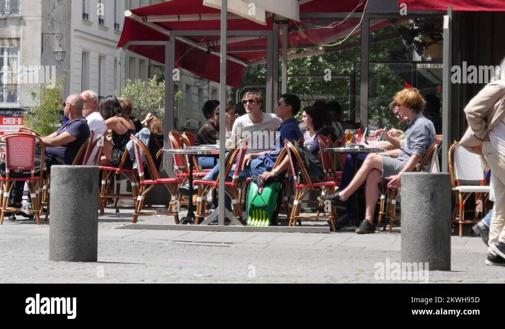 Romantic cozy street cafe tables with people sit and communicate in ...