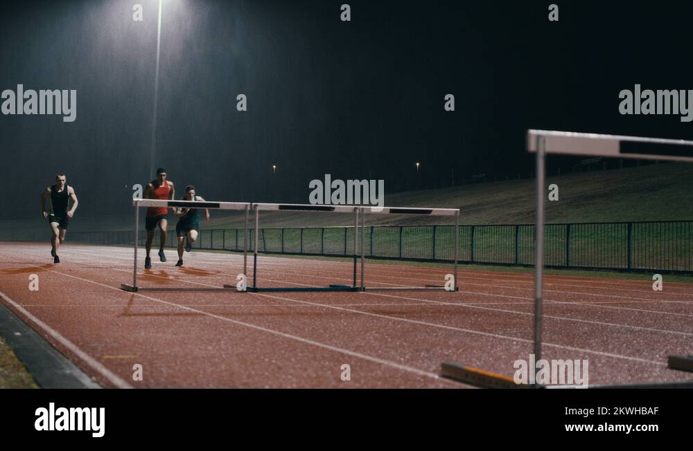 4K Competitive athletes running & jumping over hurdles at athletics ...