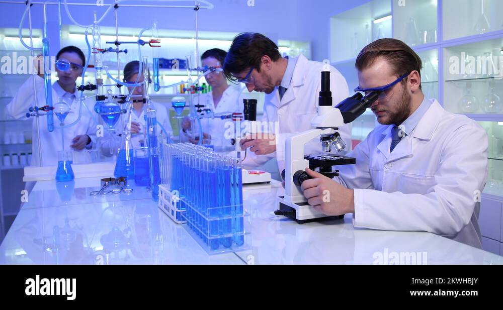 Team of Researcher Examine Samples on Microscope Modern Laboratory ...