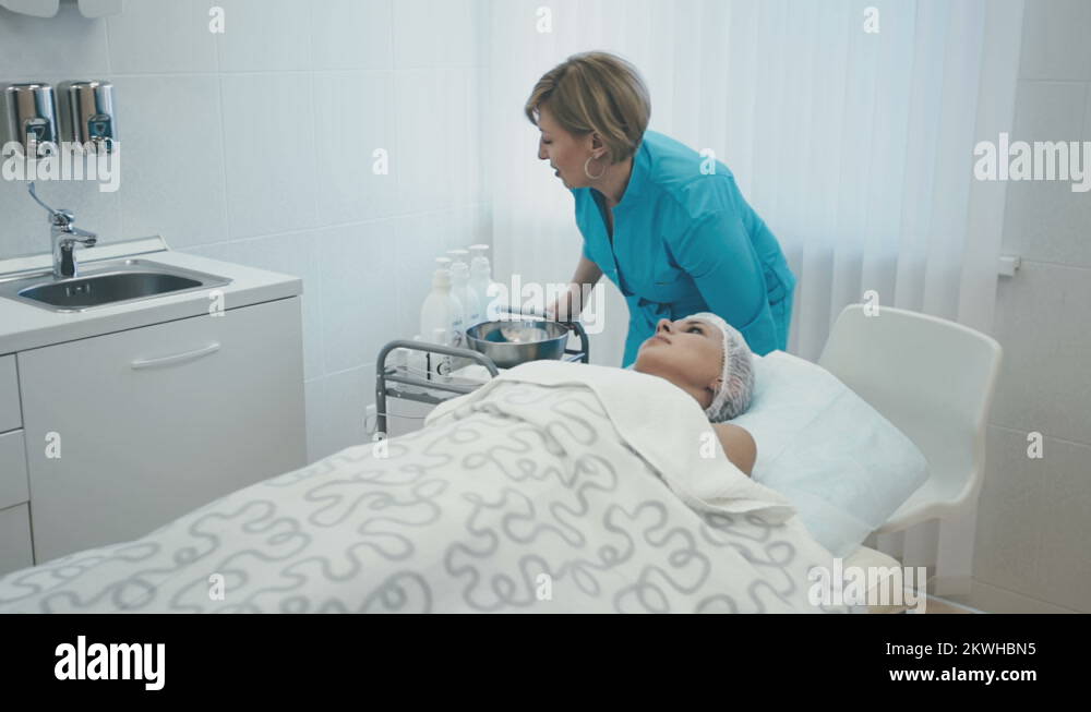 Employee of the spa salon prepares a cream for applying to the face of ...