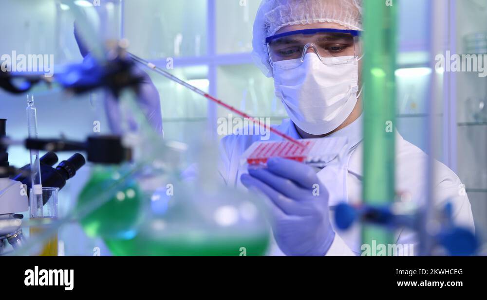 Researcher Man Using Micropipette Dropping the Solution in Microplate ...