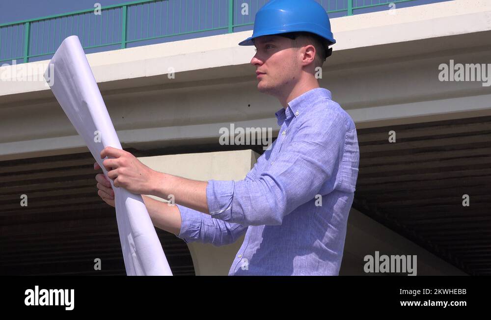 Positive cheerful architect man looking over blueprint plan appreciate ...
