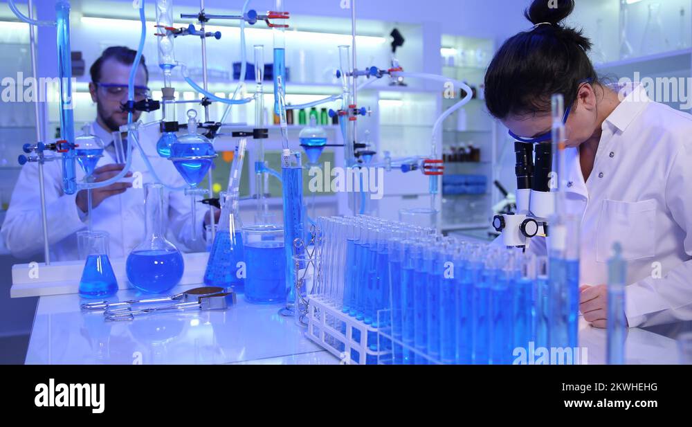 Group of Scientists Looking Through Microscope Team Work Talking in ...