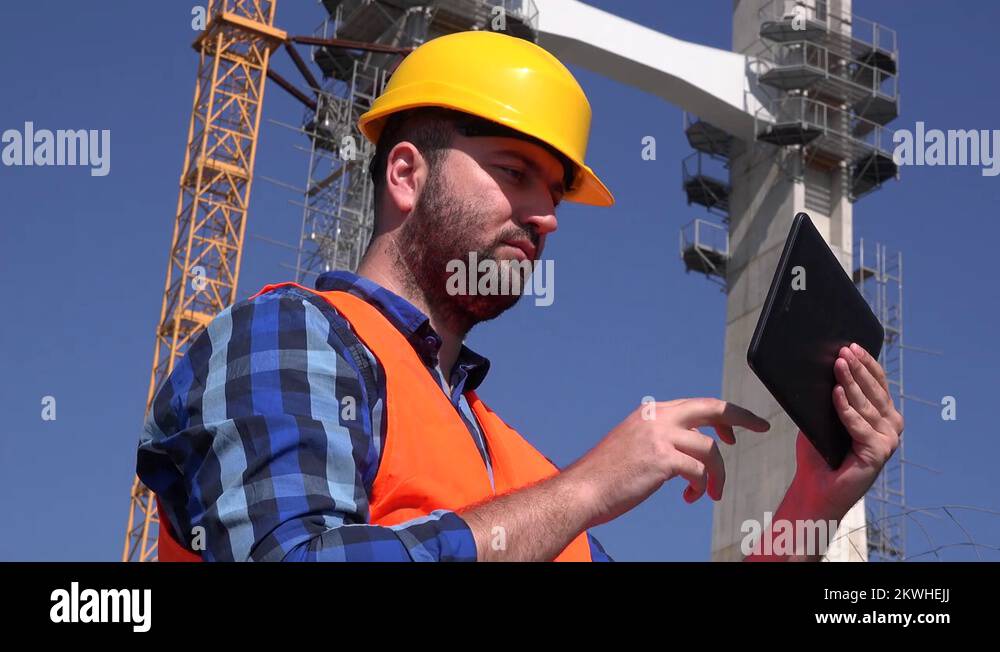 Portrait of workman handyman builder reading tablet notes smiling happy ...