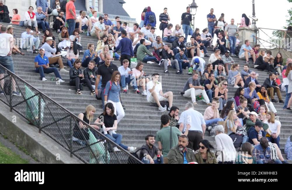 People tourists crowd sit rest on stairs under Sacre Coeur on ...