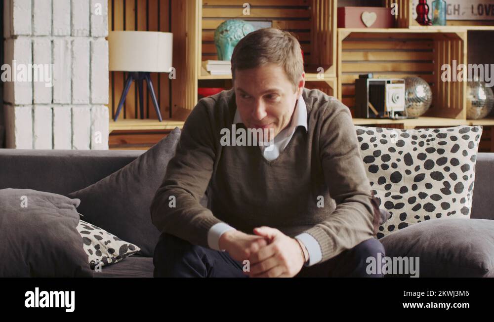 Frustrated man sitting on the couch and thinking how to solve their ...