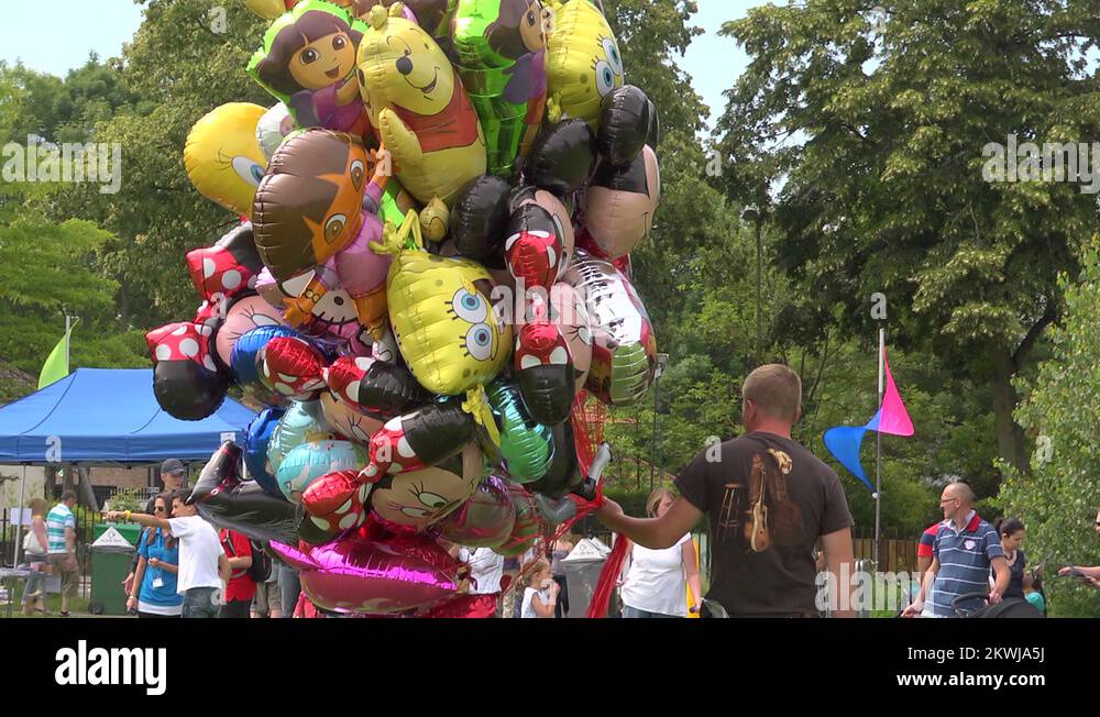 man selling helium balloons at a carnival. GV - Back view Stock Video ...