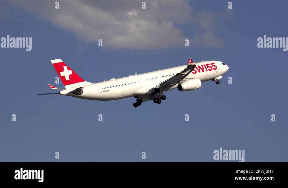 Swiss Airlines plane taking off from the airport, climbs into blue sky ...
