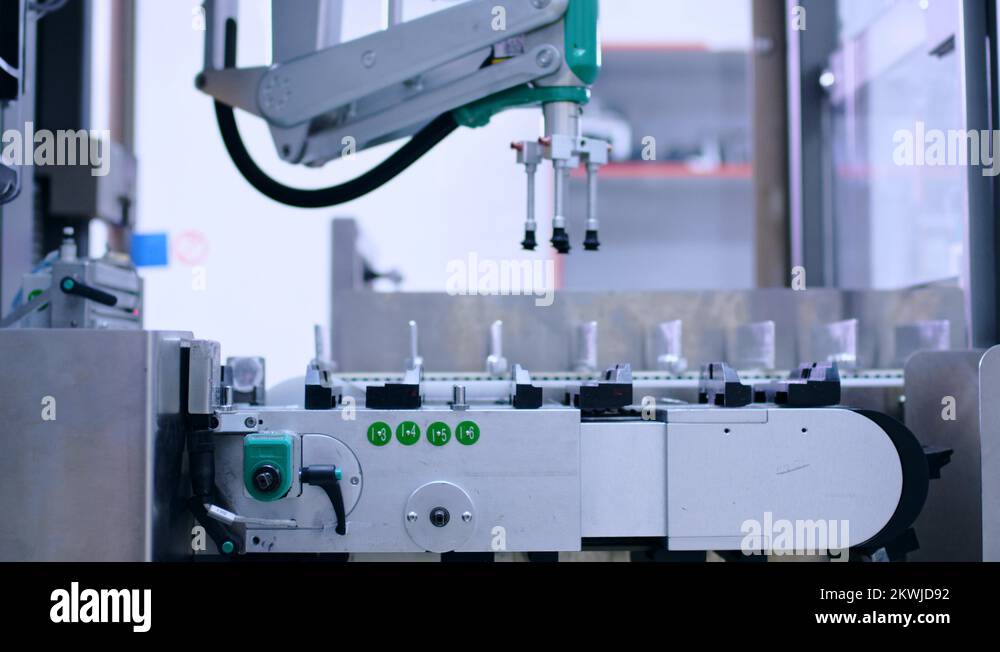 Pharmaceutical manufacturing line. Robot arm at pharmaceutical plant ...