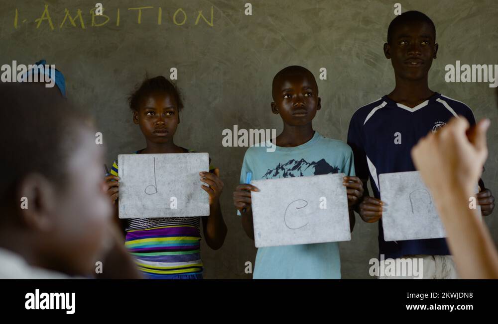 School teacher & children of African community learning together in ...