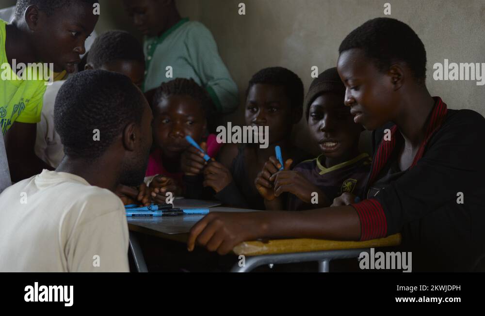 School teacher & children of African community learning together in ...