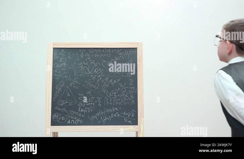 Funny child with eyeglasses getting close to chalk boar written with ...