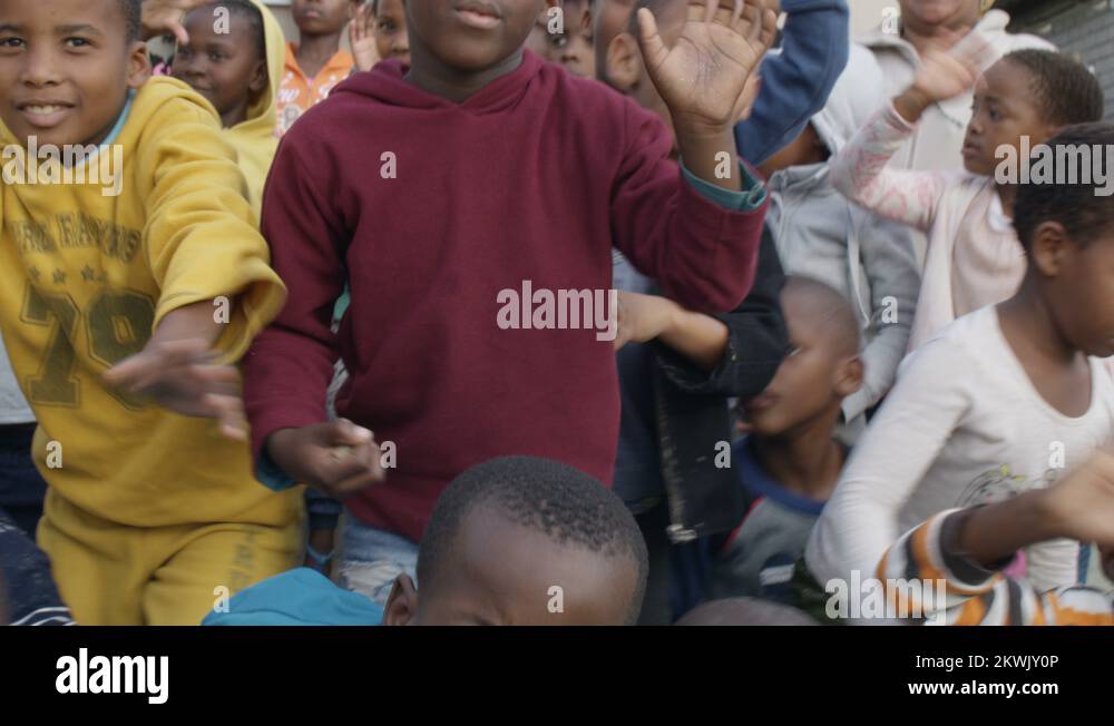 Children & adults of South African community project smile & wave at ...