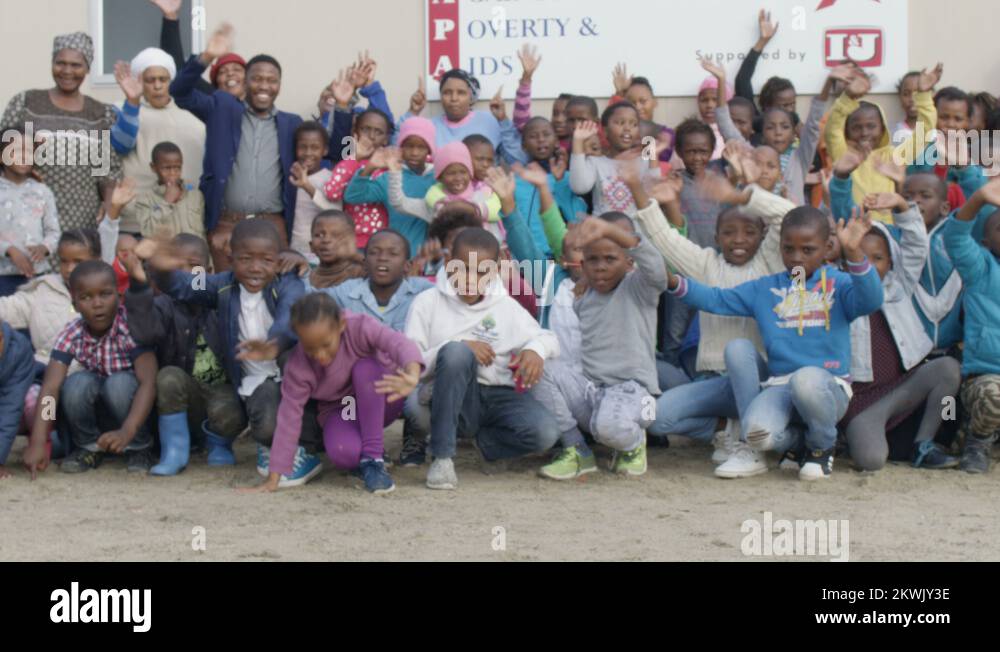 Children & adults of South African community project smile & wave at ...