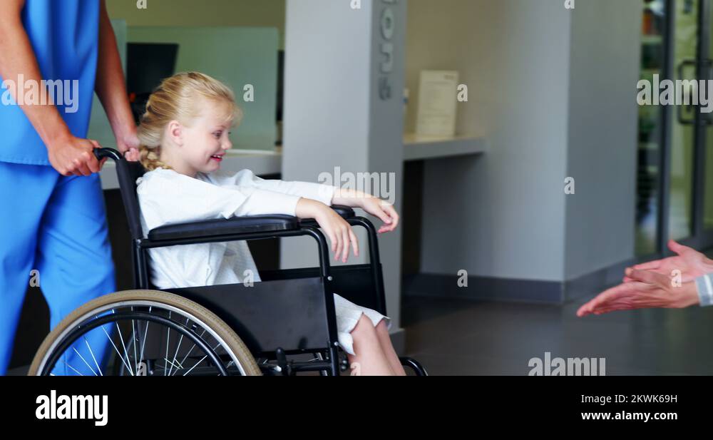 Nurse pushing girl in wheelchair Stock Video Footage - Alamy