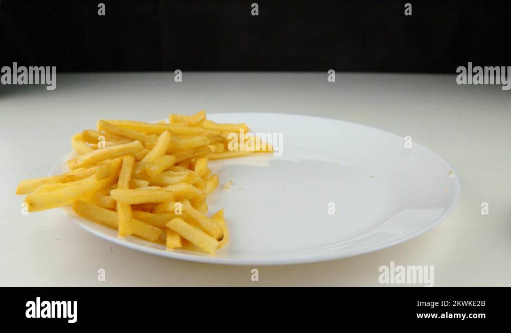 Hamburger down on fried potato chips falling, slow motion, fast food ...