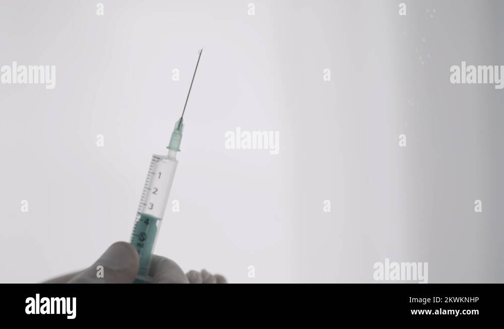 Doctor is filling medication into a syringe from vial for injection ...