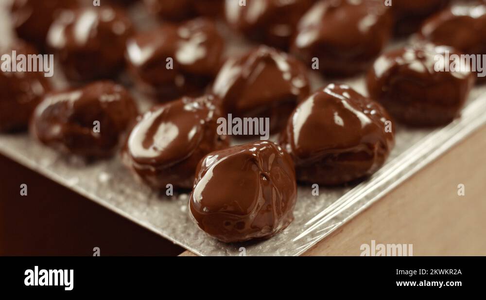 Chocolate master in his factory makes a truffles. Chocolate truffles ...