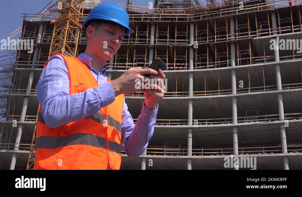 Workman engineer typing email message on smart phone foreman builder ...
